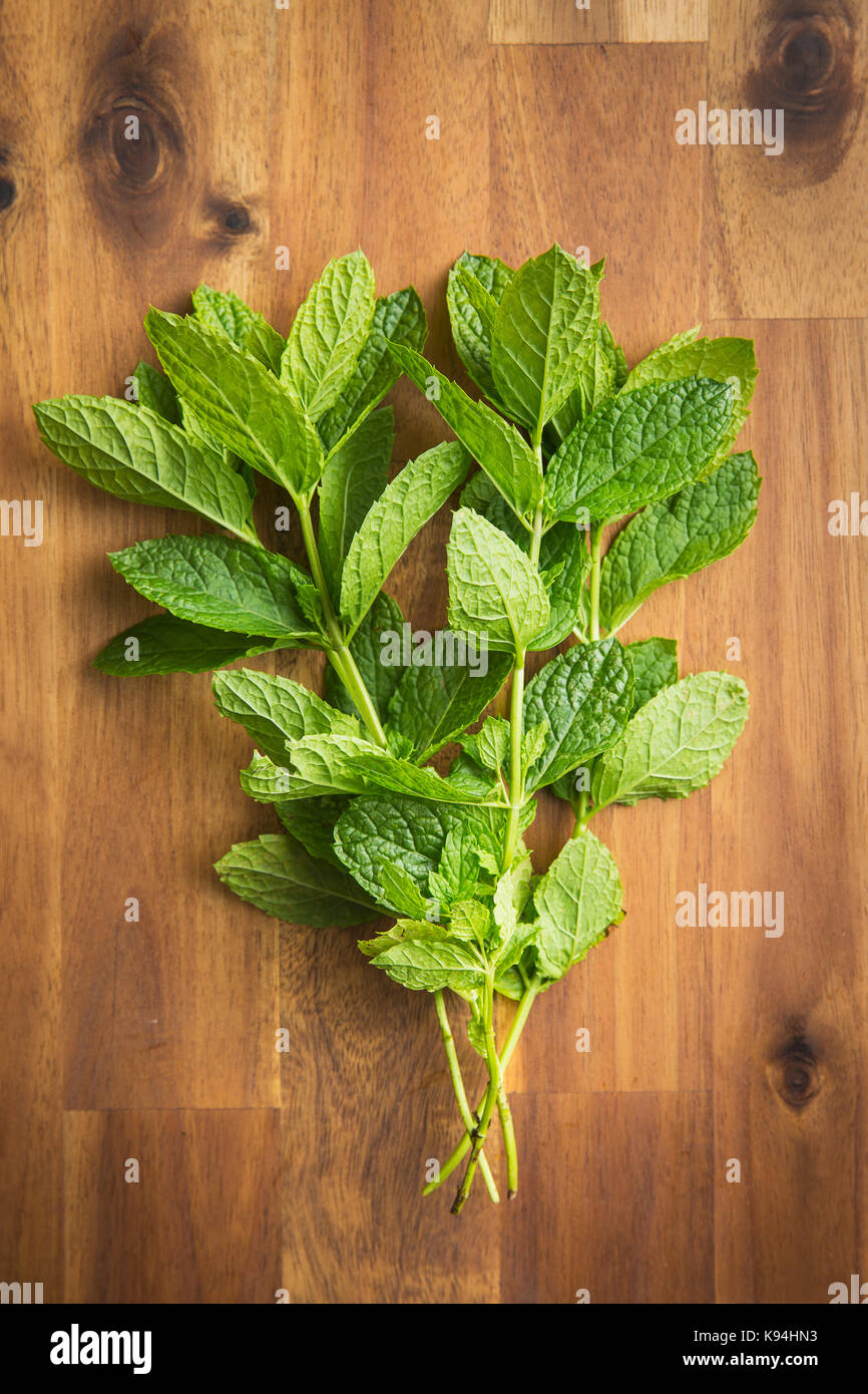Branch mint leaves on wooden table. Top view Stock Photo - Alamy