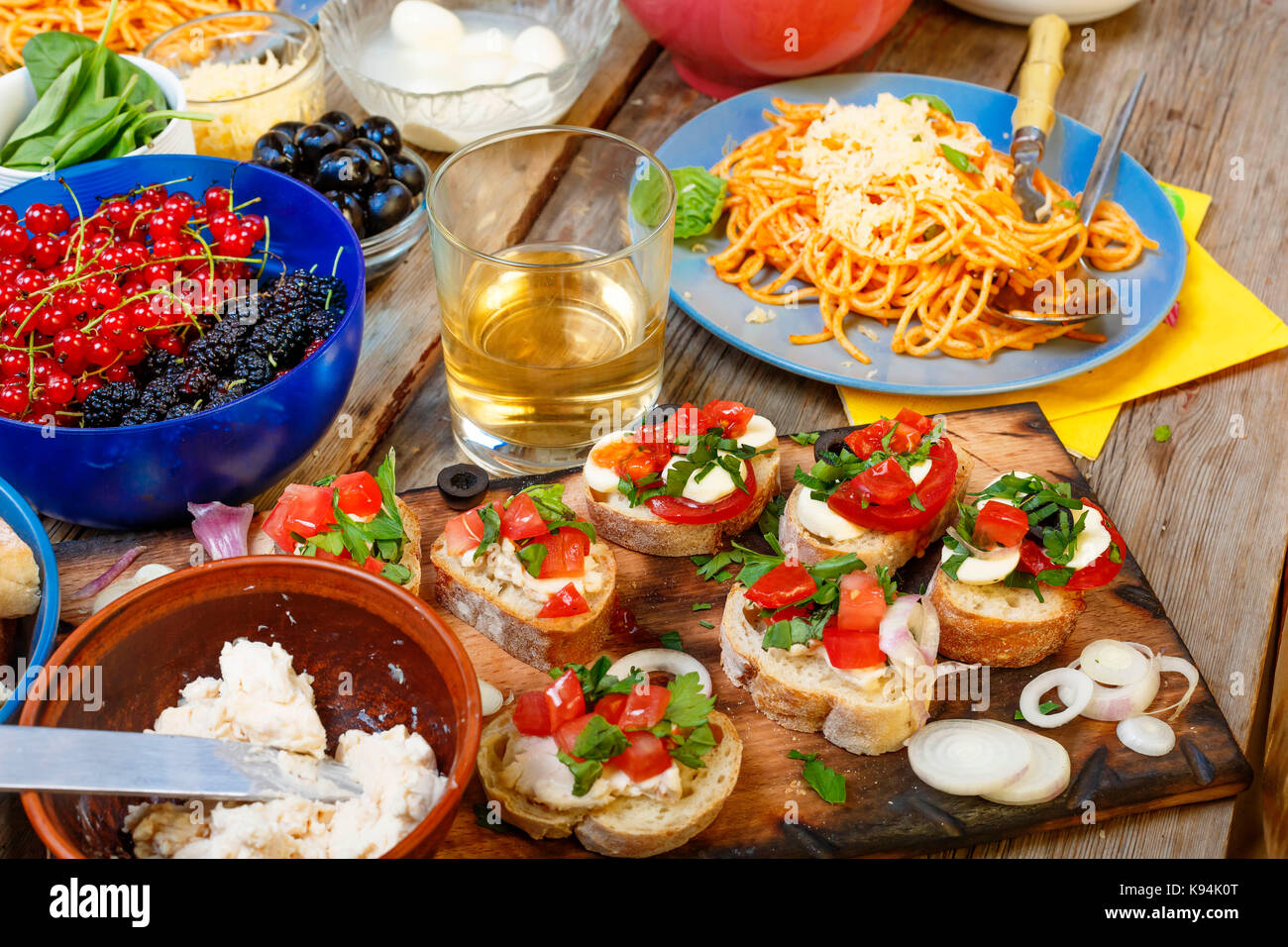 Varied snacks on the dining table, wine, pasta and bruschettes with ...