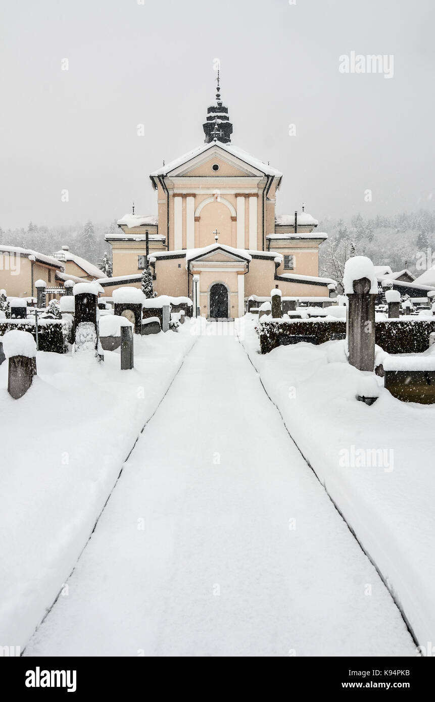 Cemetery and catholic church covered in snow in winter time. Religious ...