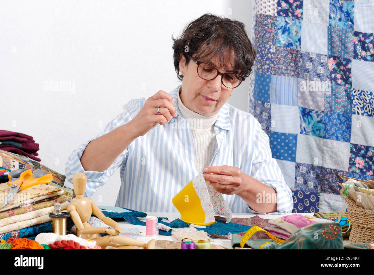 a mature brunette woman sewing patchwork Stock Photo - Alamy