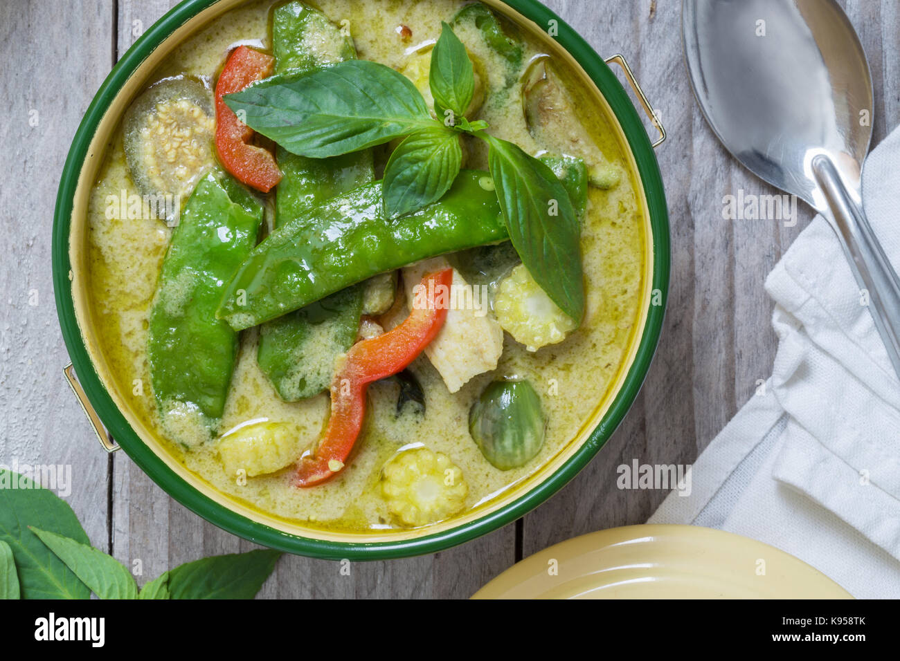 Green Thai curry in a bowl on wooden table Stock Photo - Alamy