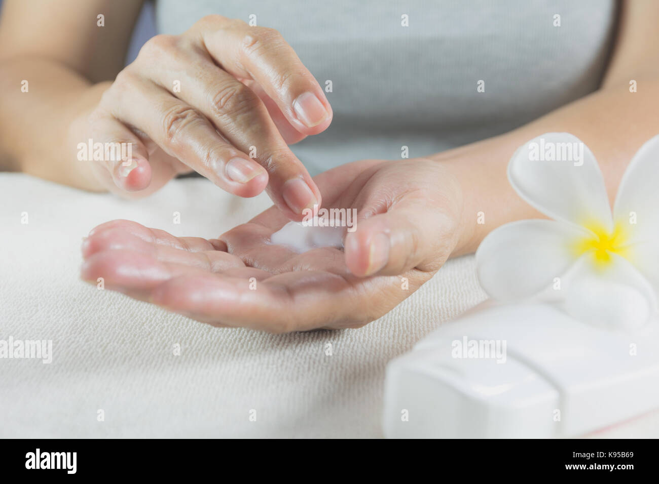 hand of woman apply lotion on skin of hand with lotion bottle on white ...