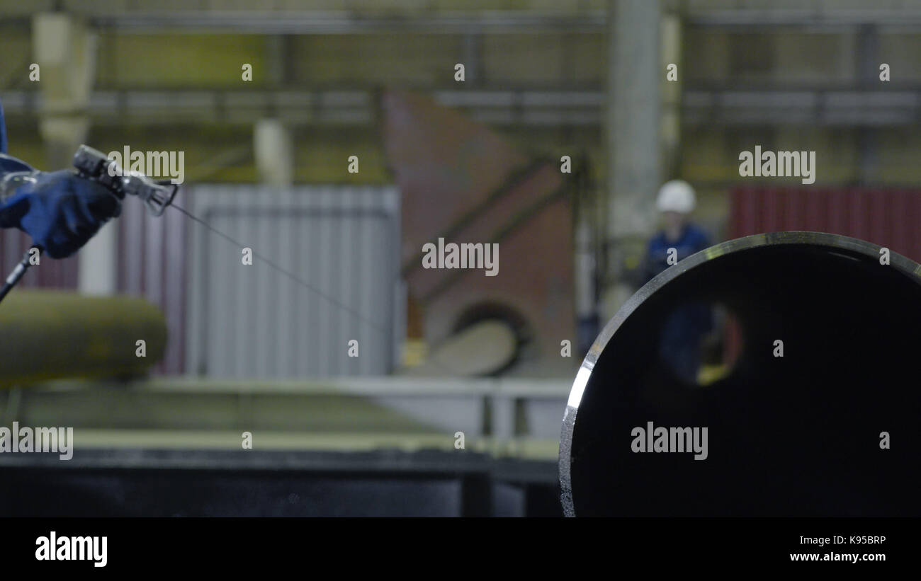 Man paints pipe atomizer. Mens hand paint the pipes on the plant ...