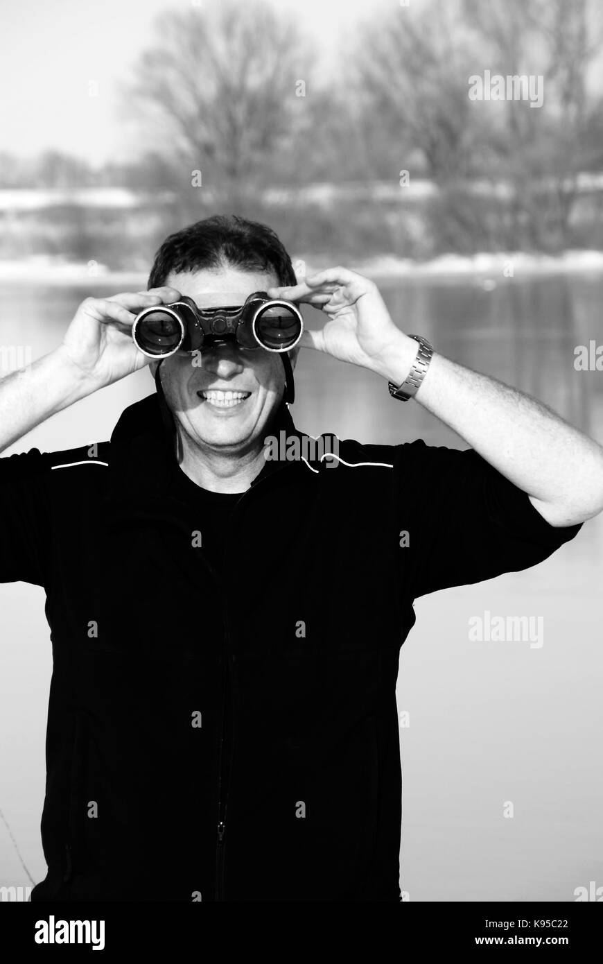 Man looking in the distance with binoculars Stock Photo - Alamy