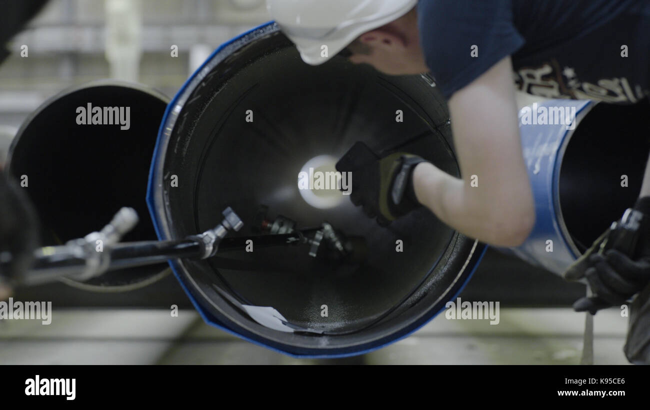 Working on tubular production. Men look inside the pipe Stock Photo - Alamy