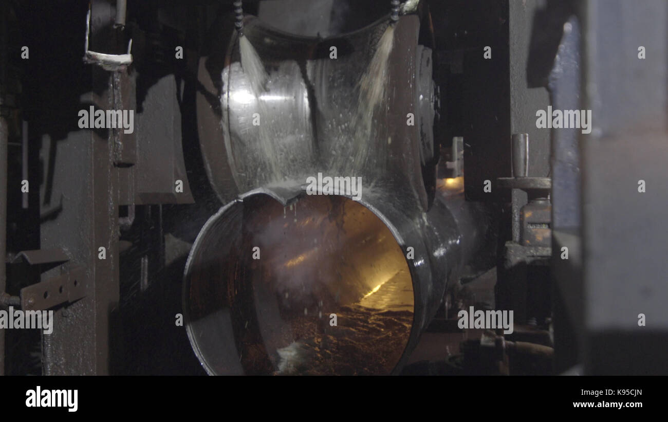 Tube rolling process at manufacturing plant. Closeup of production ...