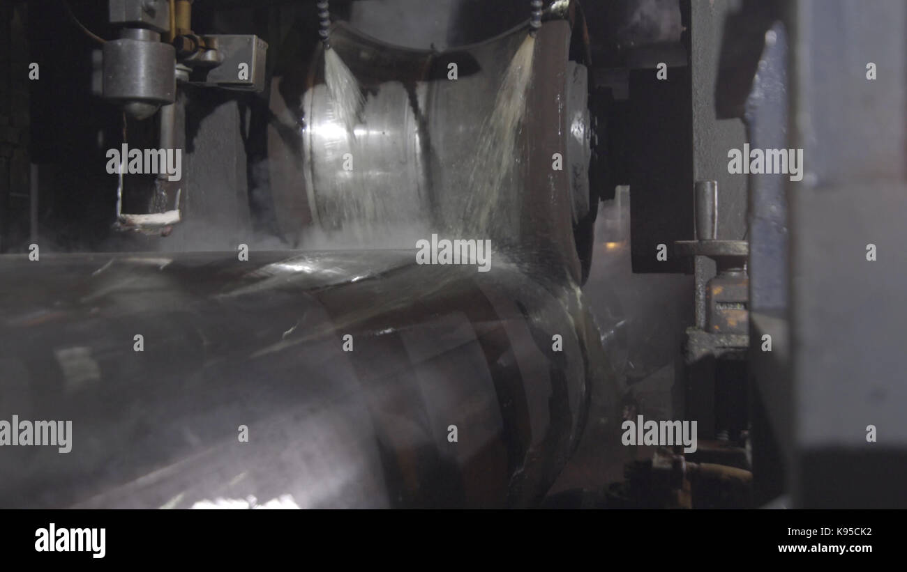 Tube rolling process at manufacturing plant. Closeup of production ...