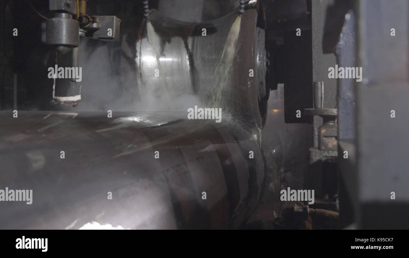 Tube rolling process at manufacturing plant. Closeup of production ...