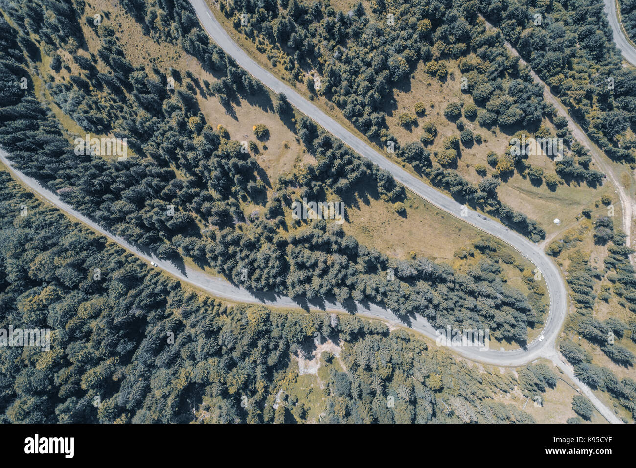 Aerial view over mountain road going through forest landscape Stock ...