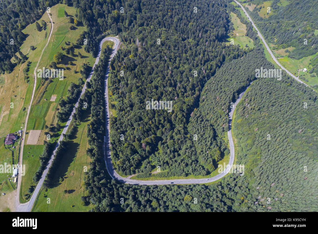 Aerial view over mountain road going through forest landscape Stock ...