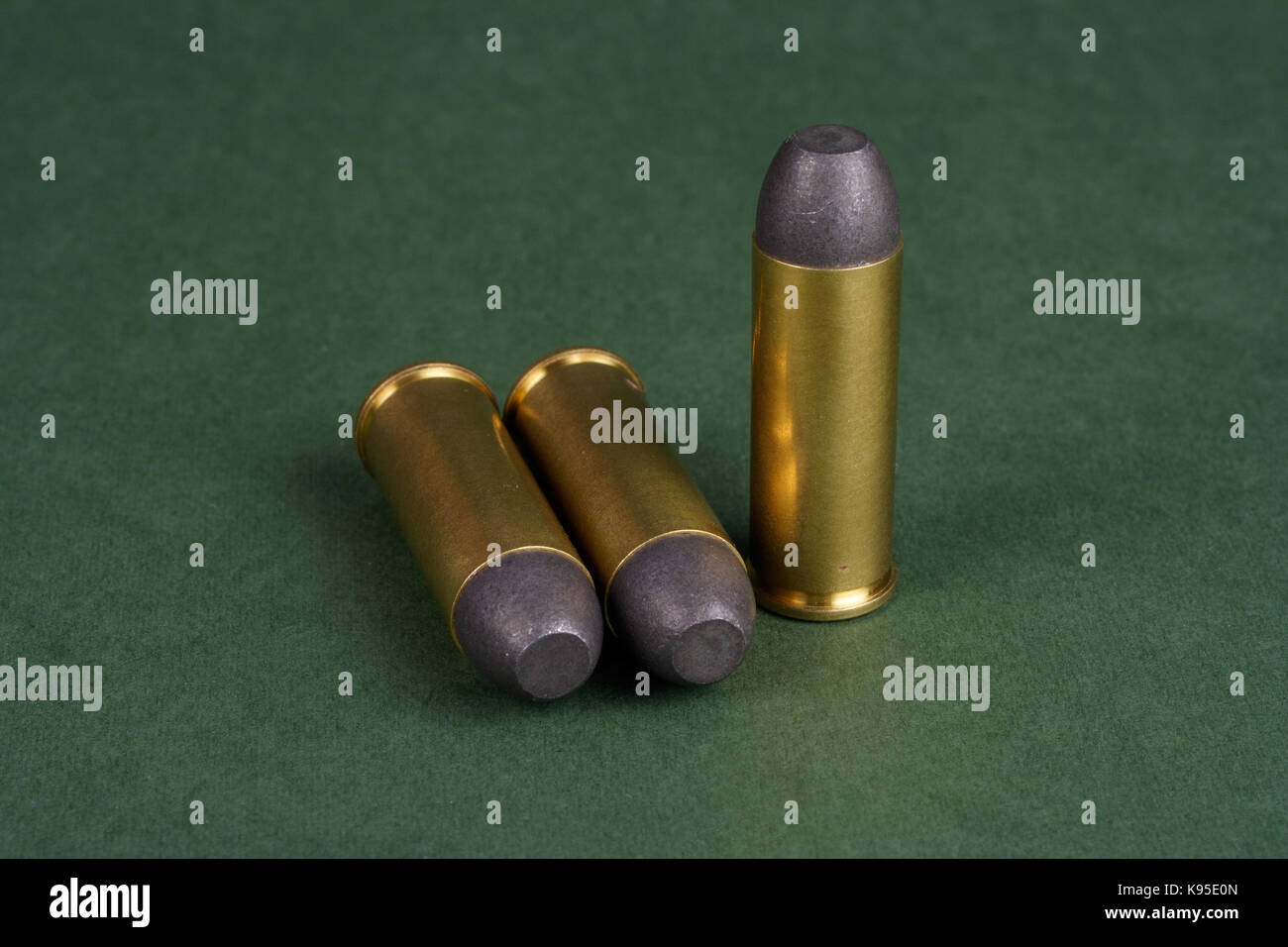 Western-style revolver cartridges on green background Stock Photo - Alamy