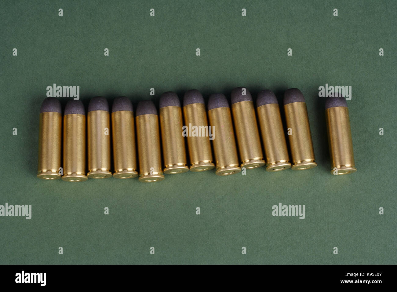 Western-style revolver cartridges on green background Stock Photo - Alamy