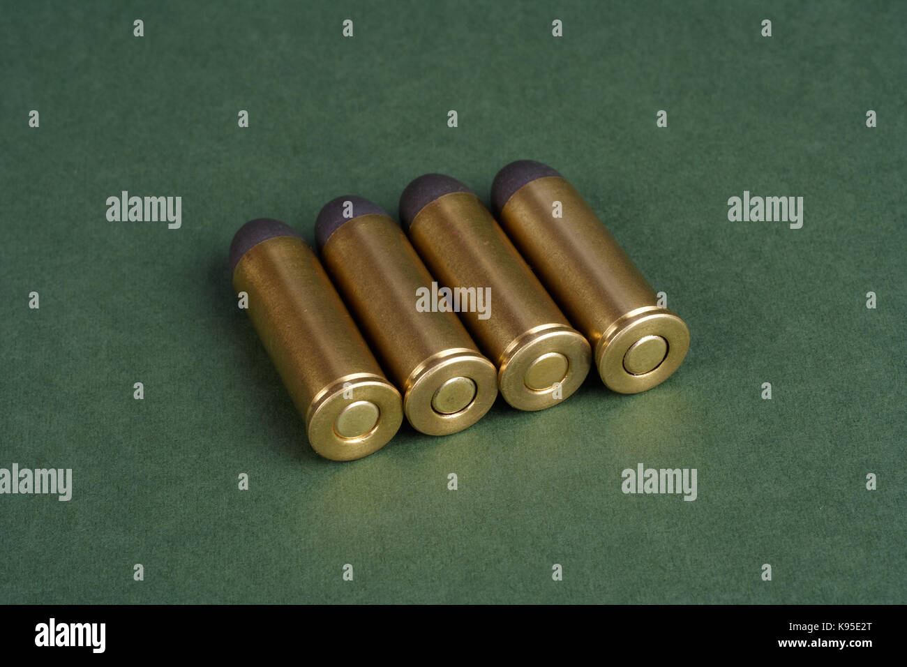 Western-style revolver cartridges on green background Stock Photo - Alamy