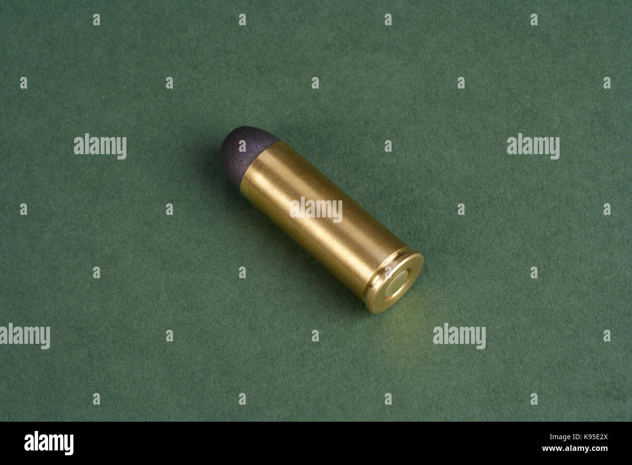 Western-style revolver cartridges on green background Stock Photo - Alamy
