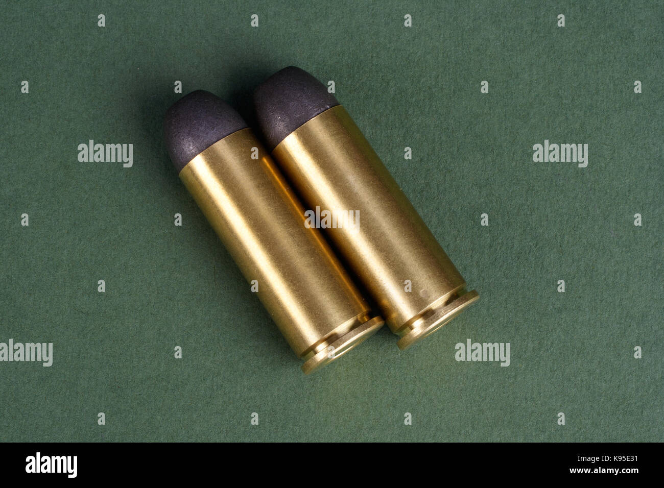 Western-style revolver cartridges on green background Stock Photo - Alamy
