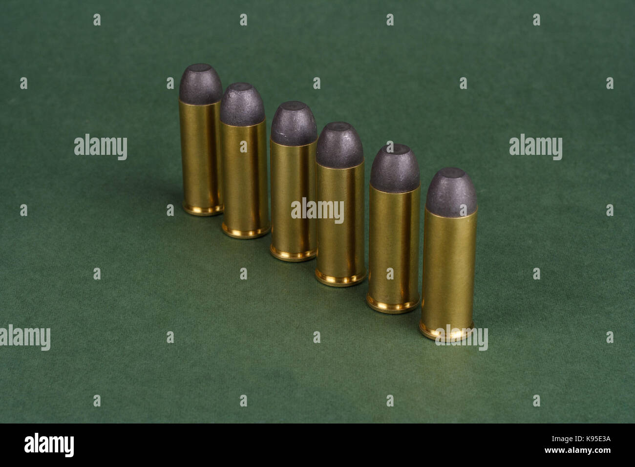 Western-style revolver cartridges on green background Stock Photo - Alamy