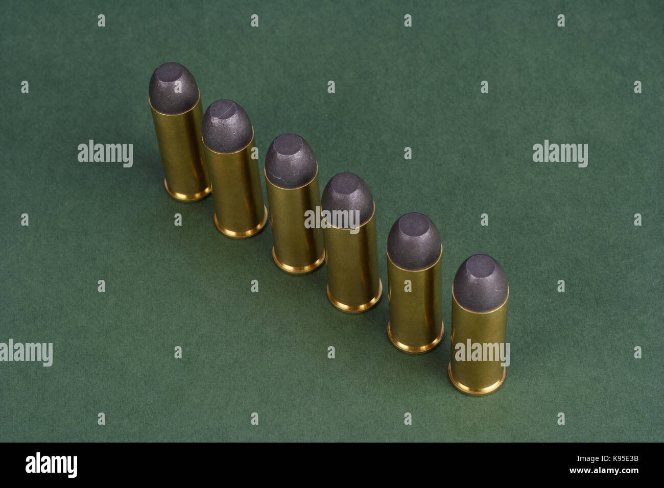 Western-style revolver cartridges on green background Stock Photo - Alamy
