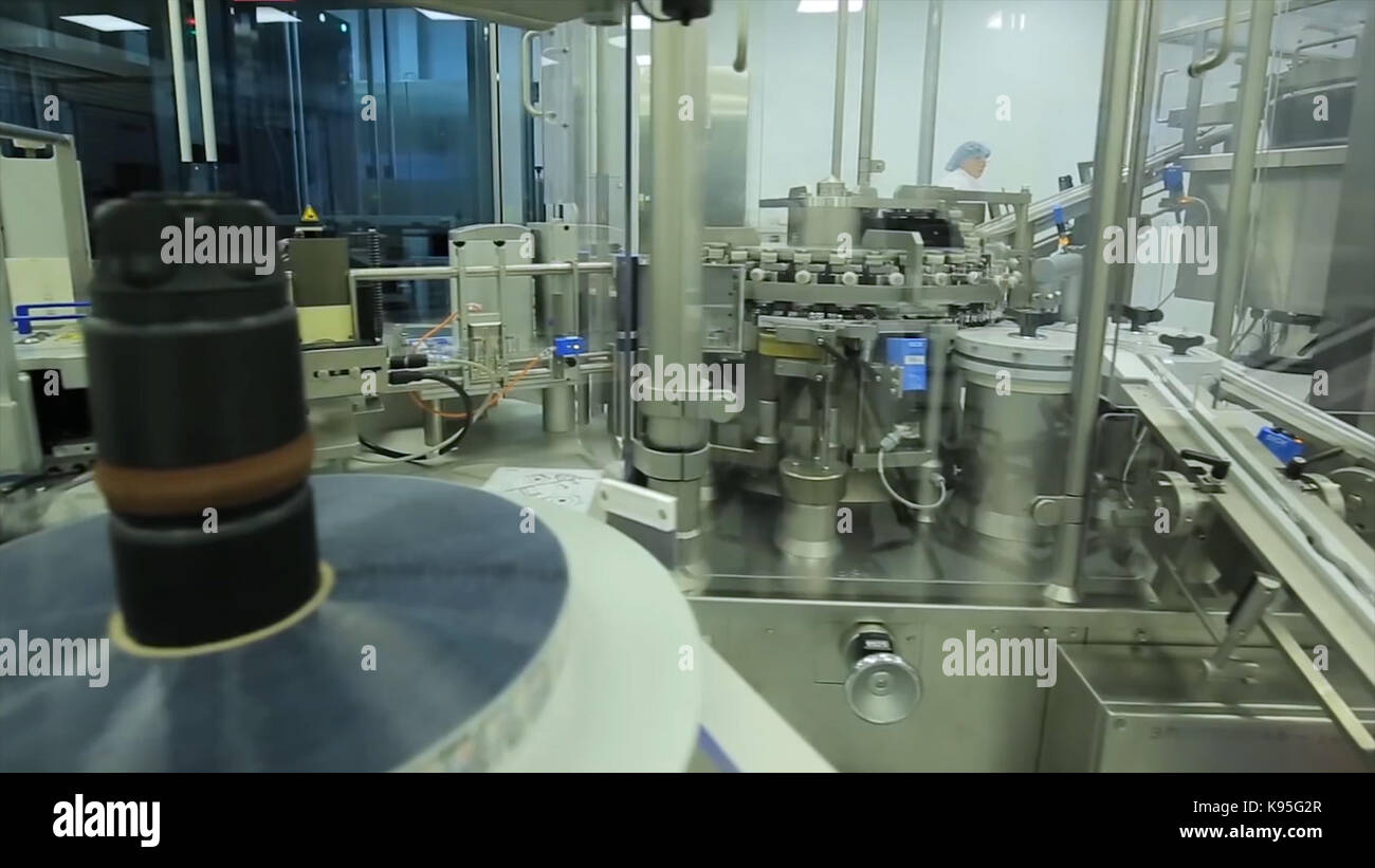 Pharmaceutics. Pharmaceutical worker operates tablet blister packaging ...