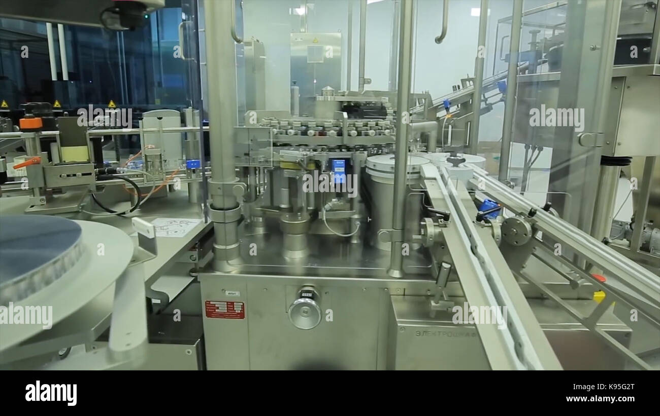 Pharmaceutics. Pharmaceutical worker operates tablet blister packaging ...