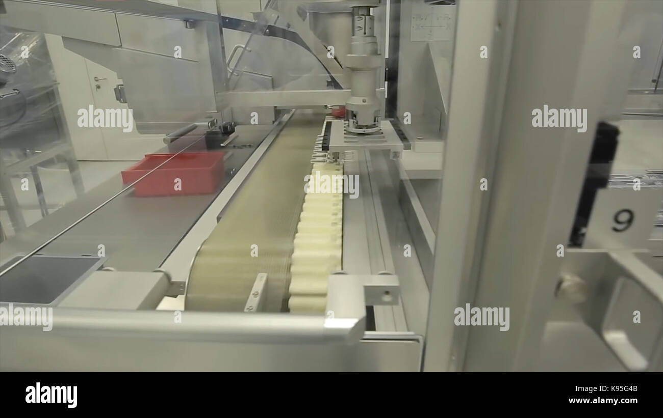 Pharmaceutics. Pharmaceutical worker operates tablet blister packaging ...