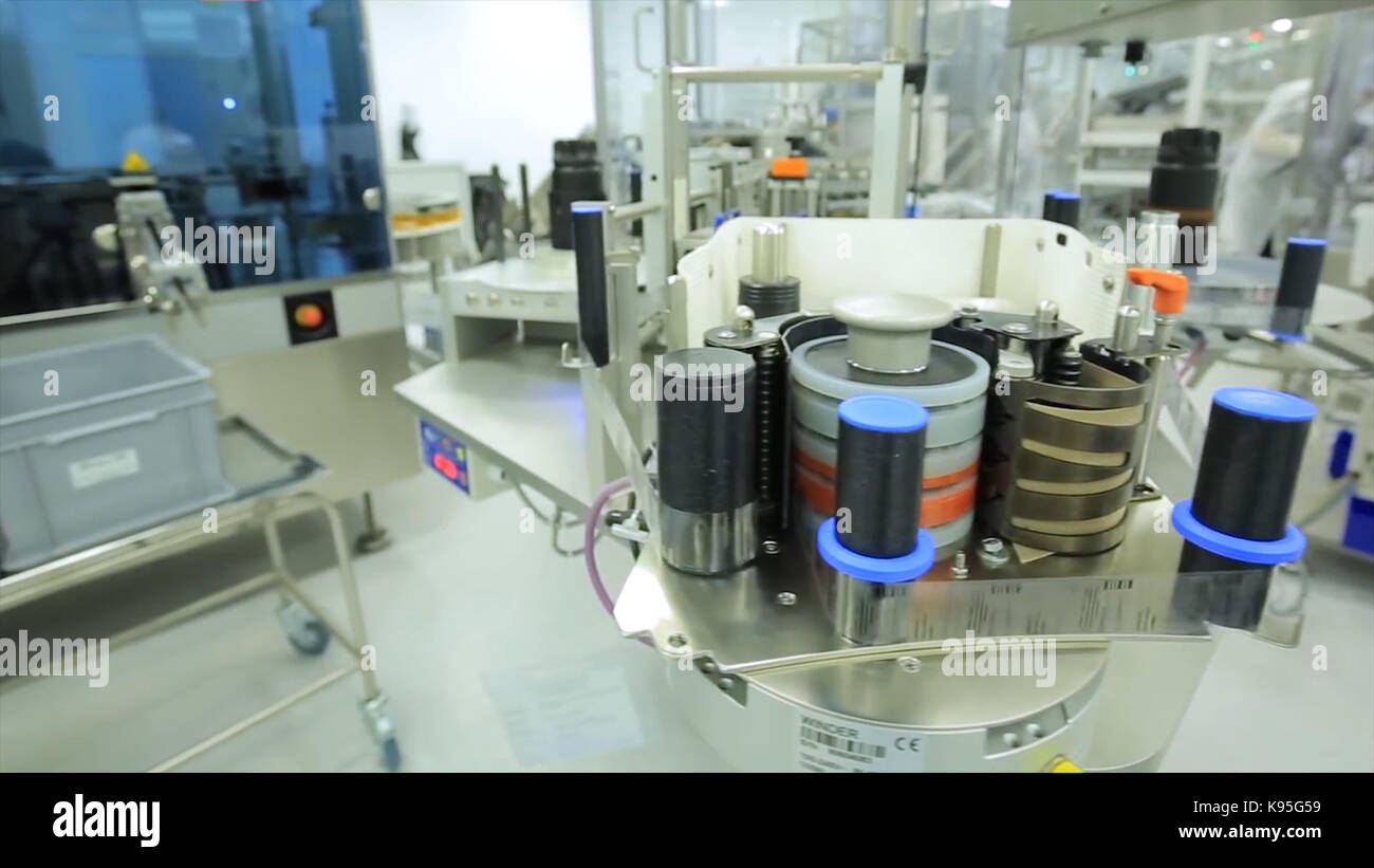 Pharmaceutics. Pharmaceutical worker operates tablet blister packaging ...