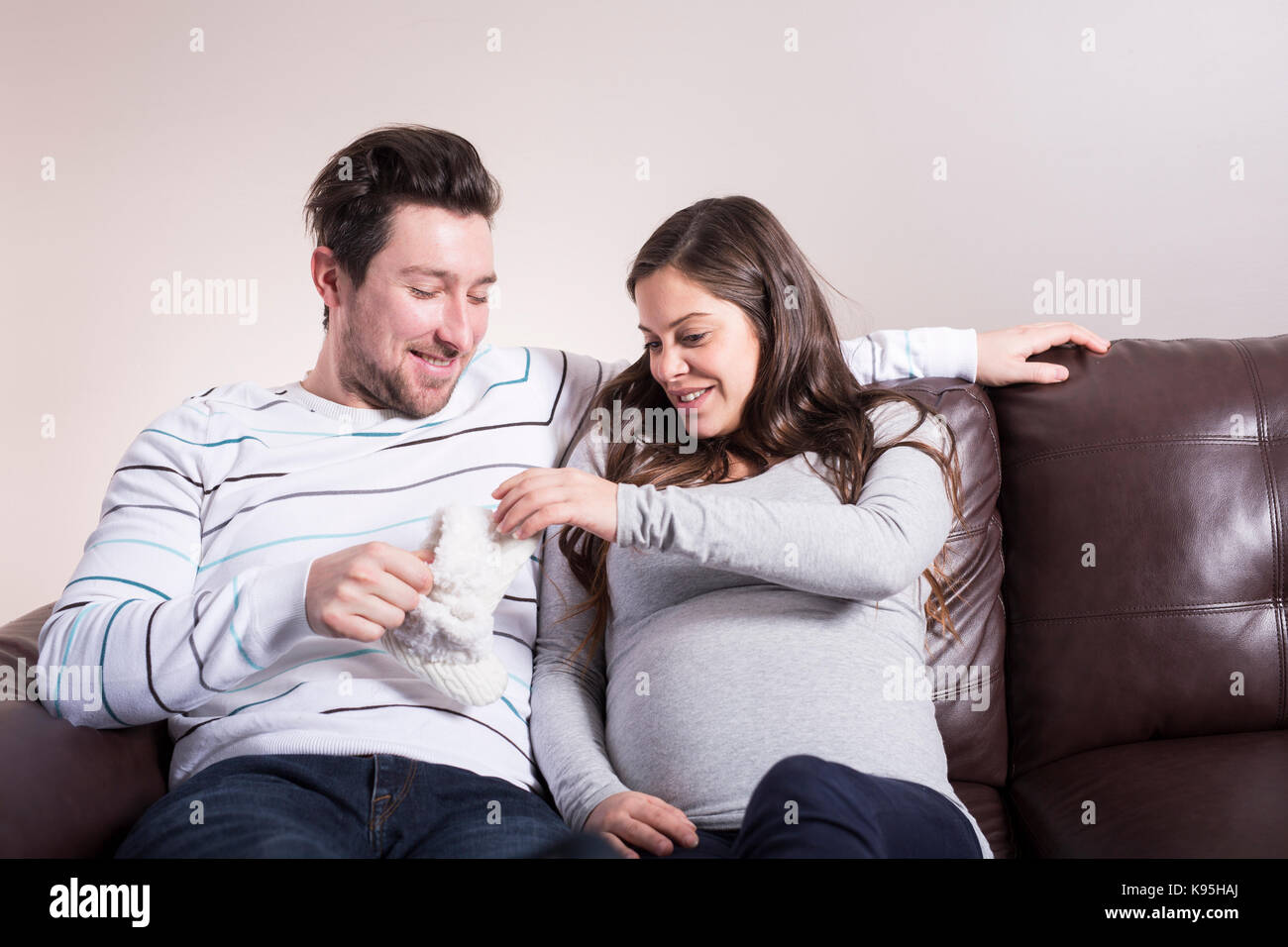 Mid-adult woman expecting baby lying on sofa Stock Photo - Alamy