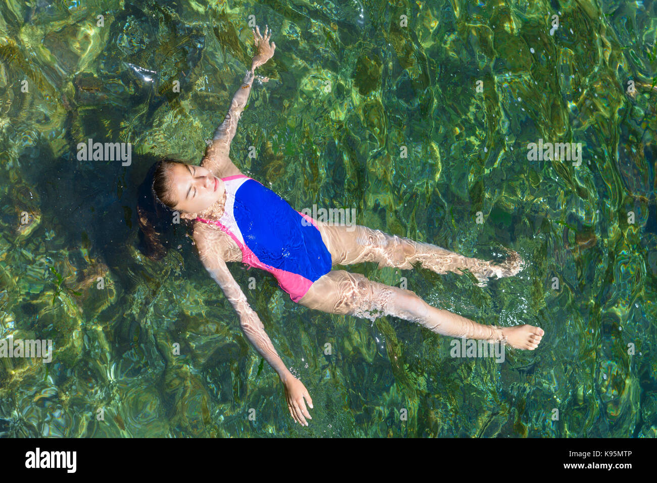 Floating on her back at sea, summer day Stock Photo - Alamy