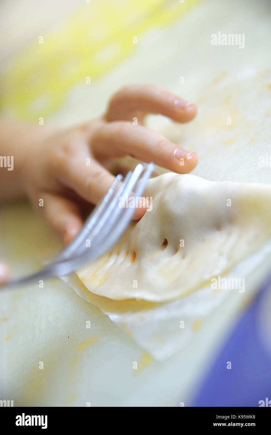 Young child hand collaborating at housework and cooking preparing some ...
