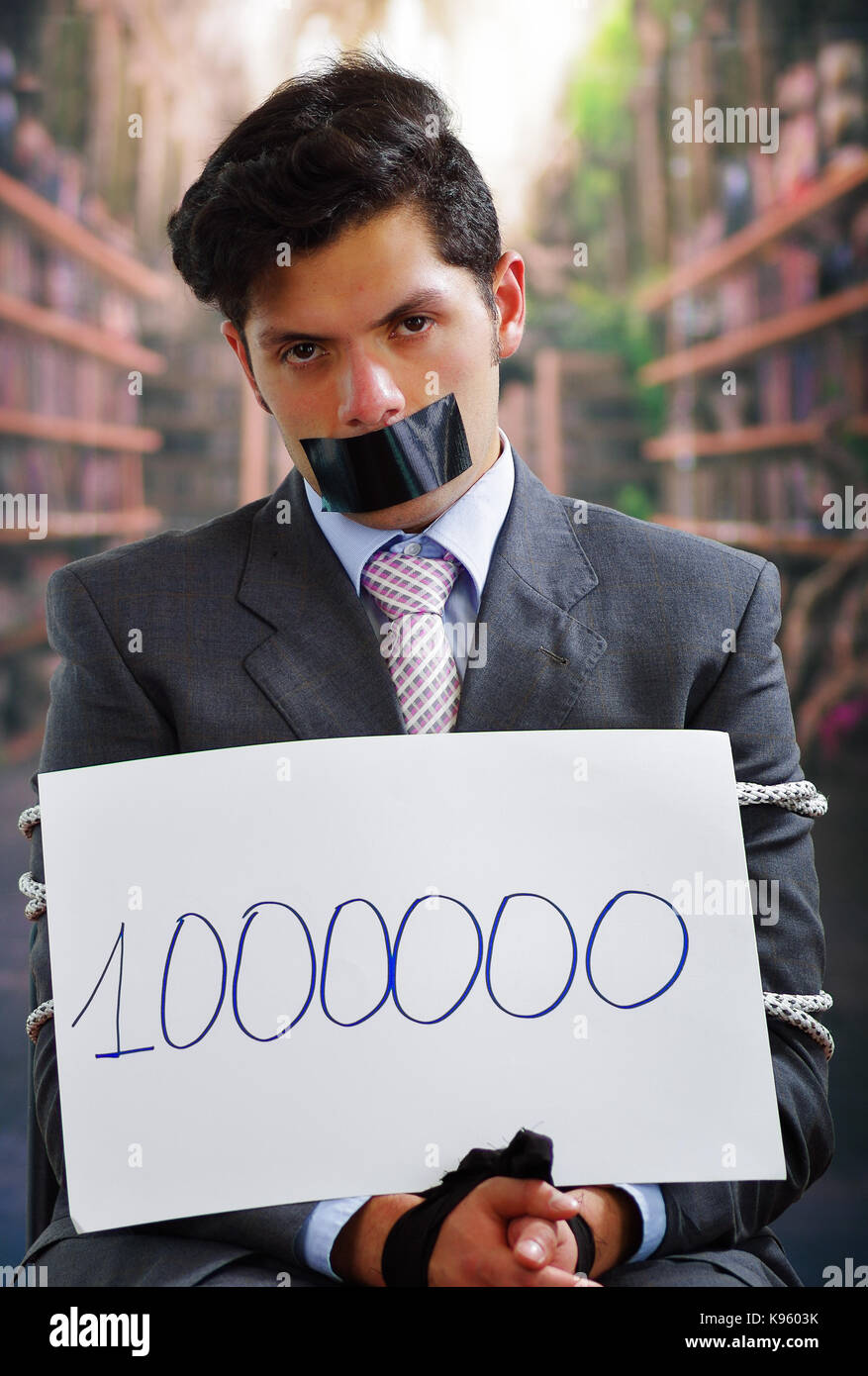 Businessman trapped in a chair with rope, with a black tape in his ...