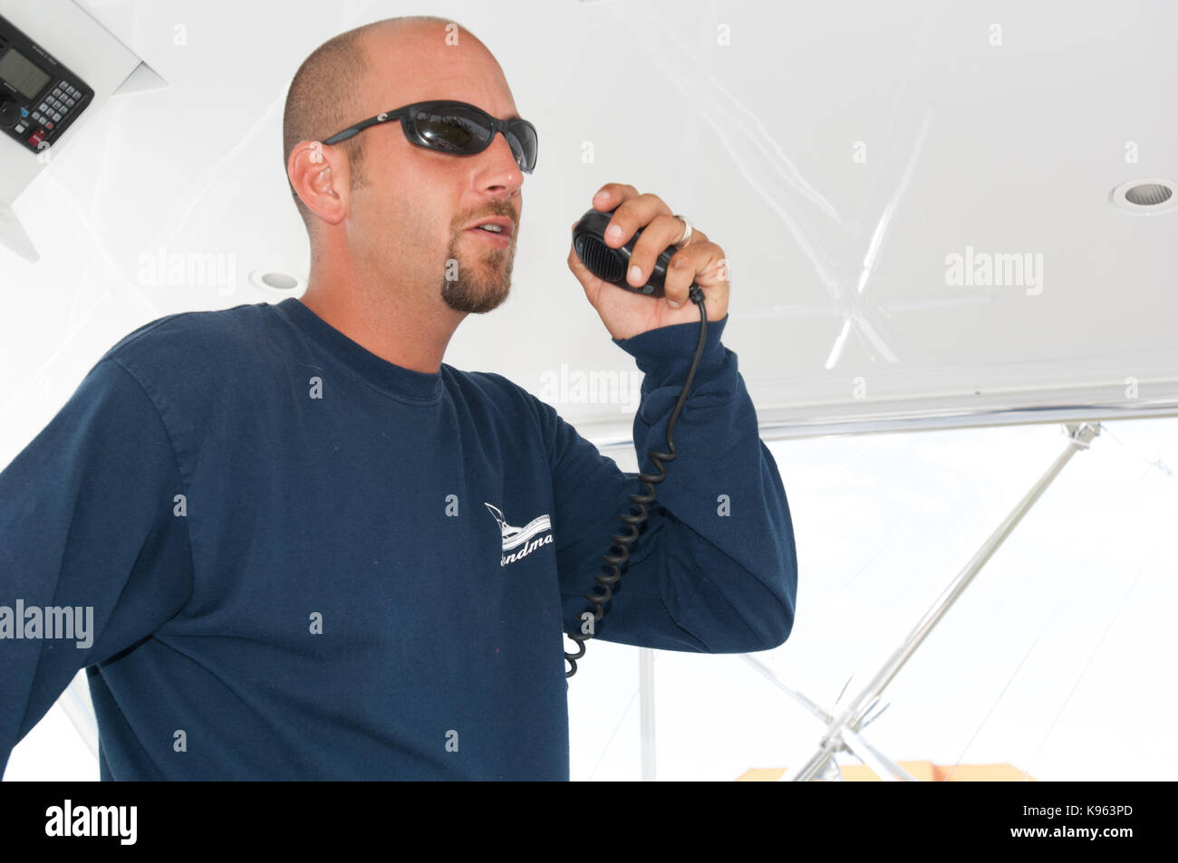 A sport fishing charter boat captain at the helm of his fishing boat ...