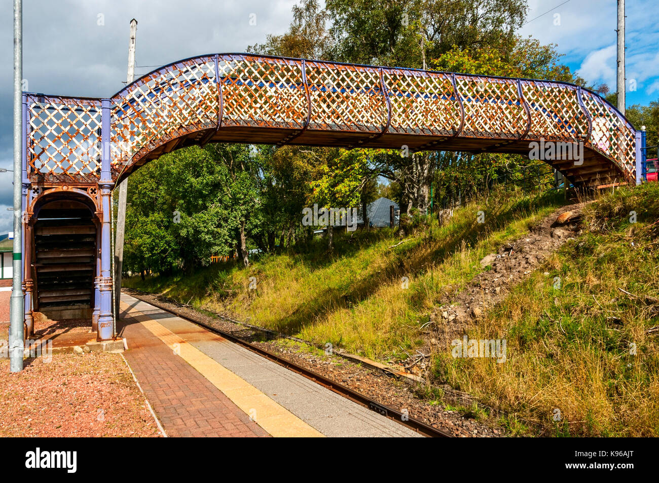 A railway passenger bridge with brown rust showing through the white ...