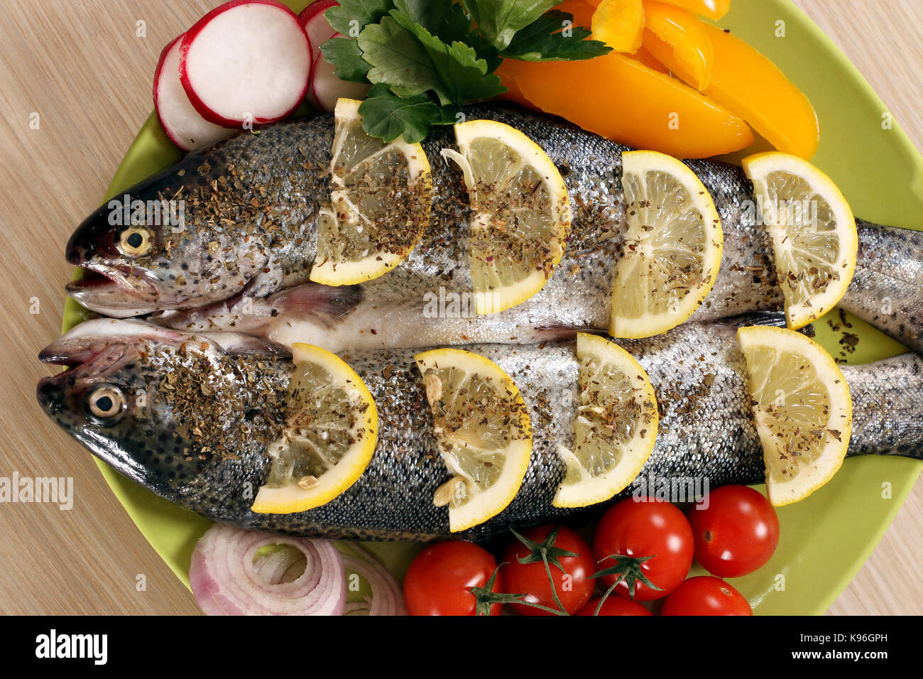 trout fish with salad on plate Stock Photo - Alamy