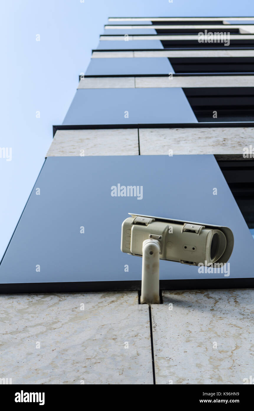 surveillance monitoring security camera on a house corner with blue sky ...