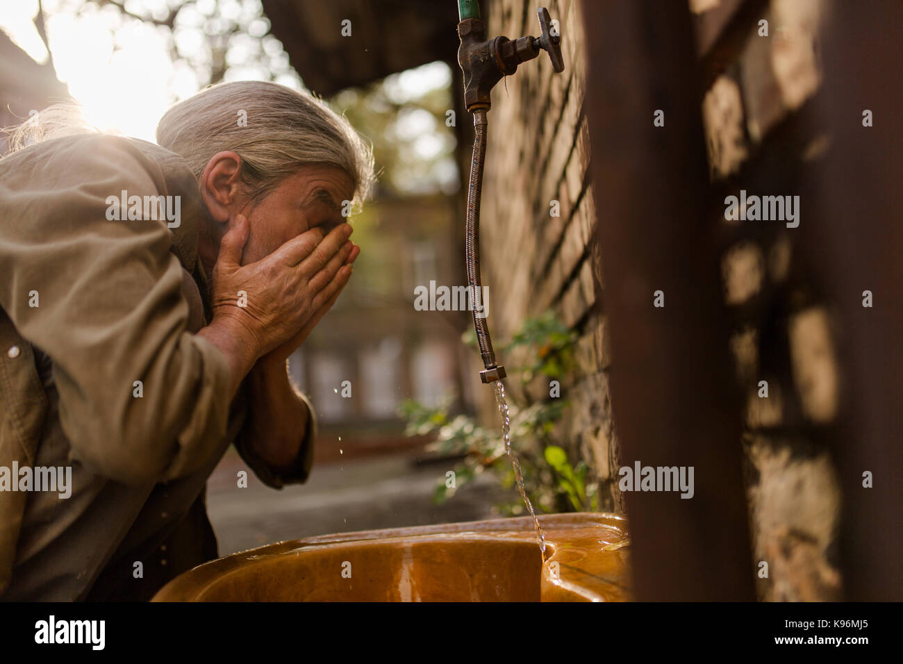 Old homeless tramp with long grey hair washing face Stock Photo - Alamy