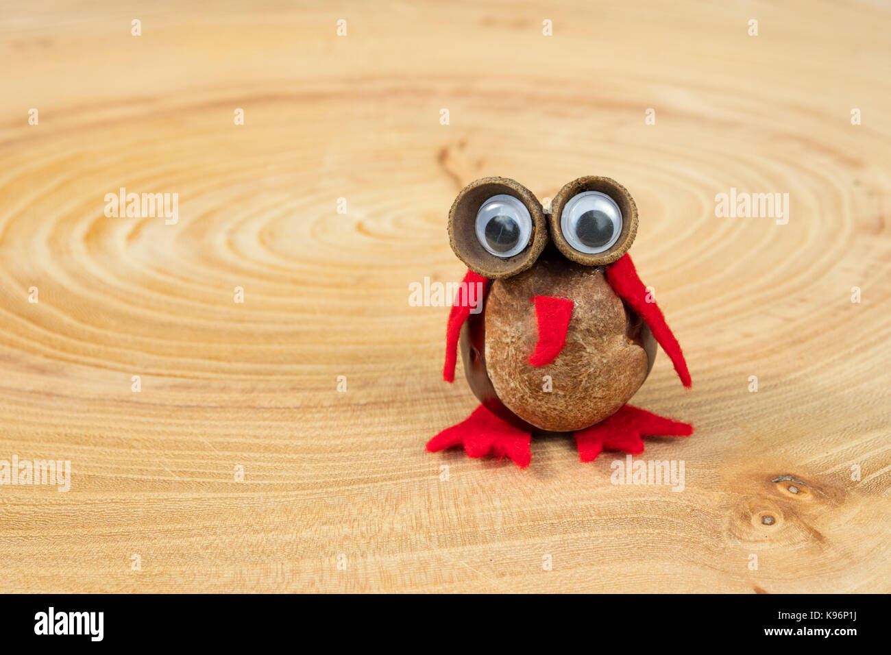 Funny owl shape character or figurine made with chestnuts on a wooden ...