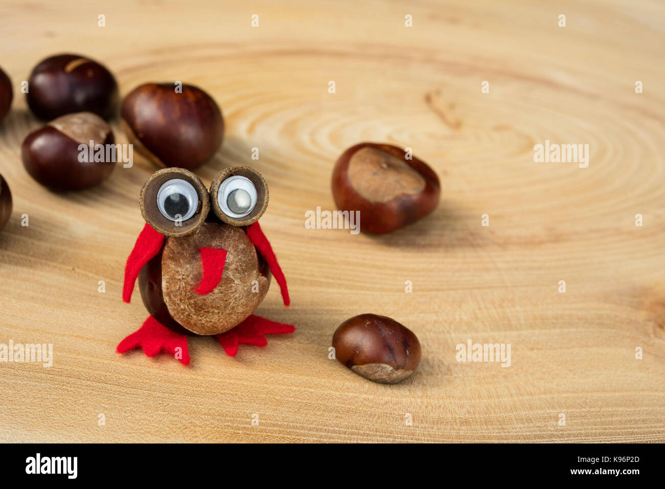 Funny owl shape character or figurine made with chestnuts on a wooden ...