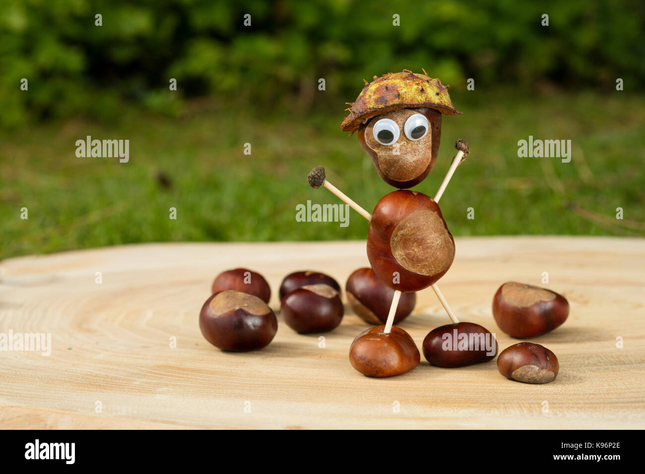 Funny human shape character or figurine made with chestnuts on a wooden ...