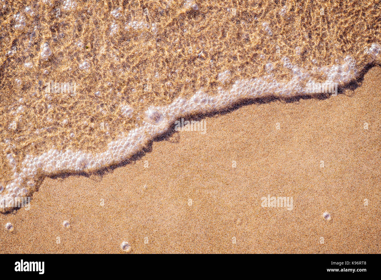 Shallow water line on a sandy beach top view. Natural texture an ...