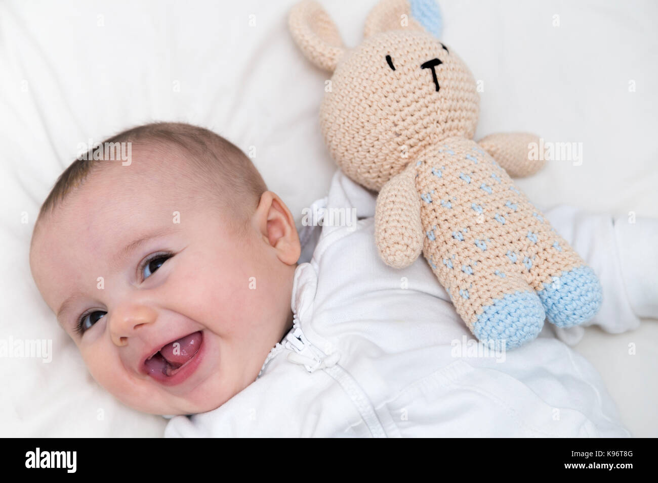 BABY WITH DUMMY. Little baby boy resting on the bed happy and smiling ...