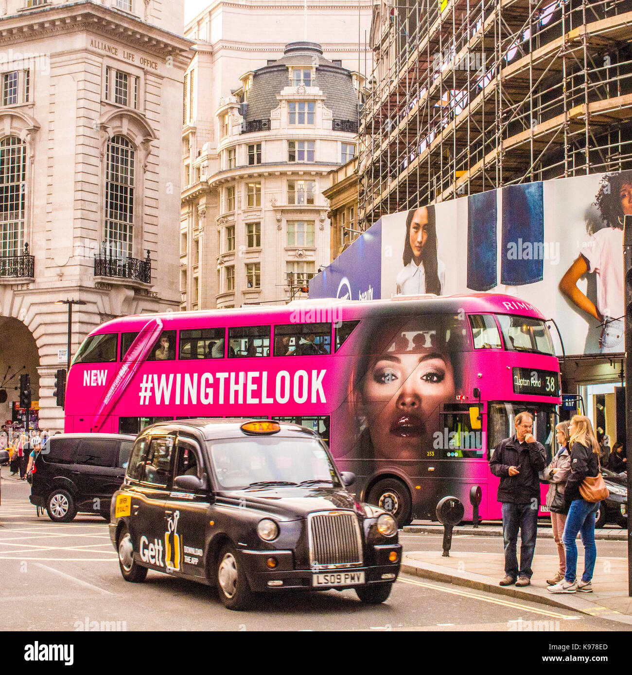 Purple coloured bus & a taxi at Piccadilly Circus London Stock Photo ...