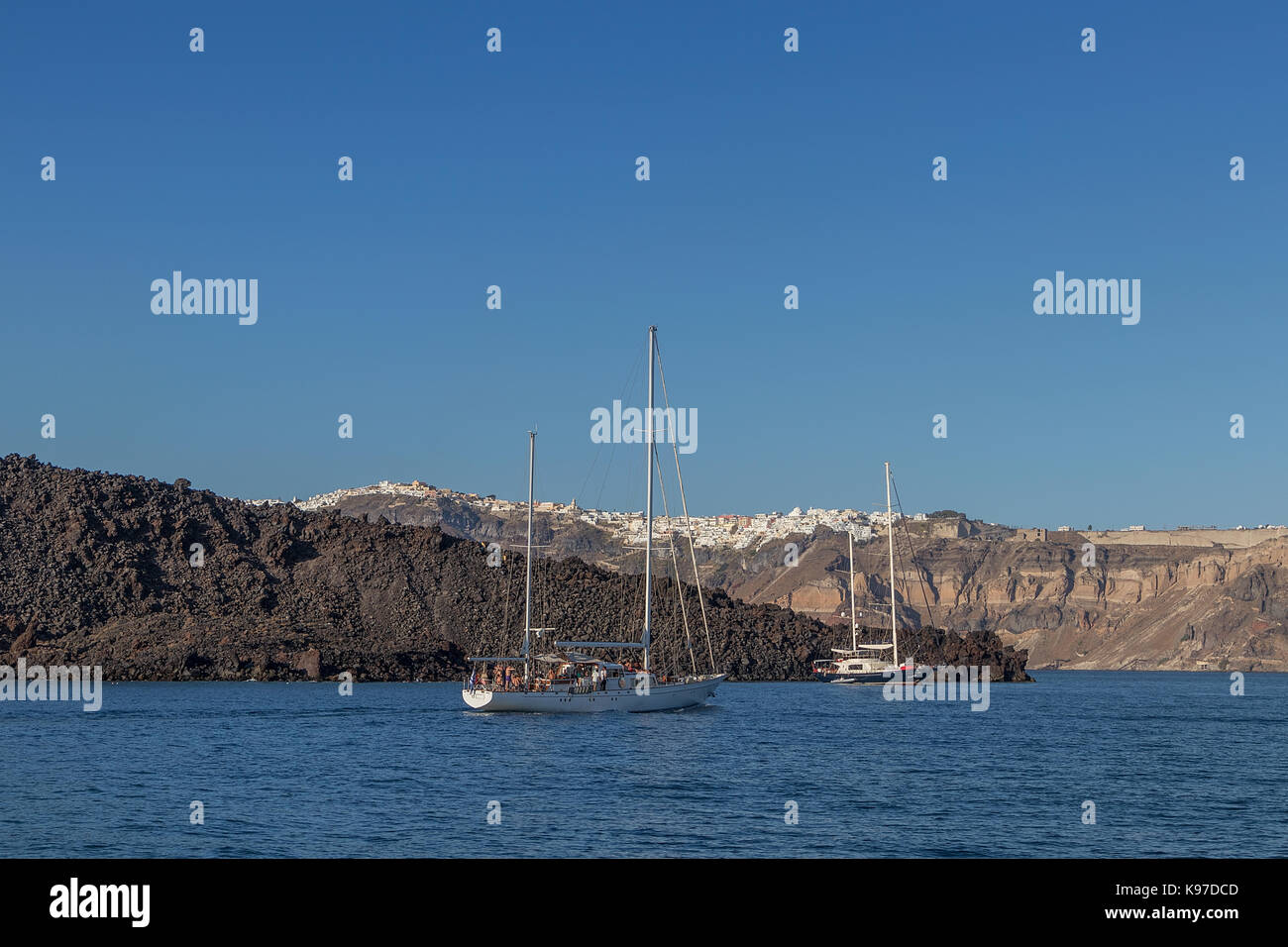 sailboat with cliff behind in the sea of santorini Stock Photo - Alamy