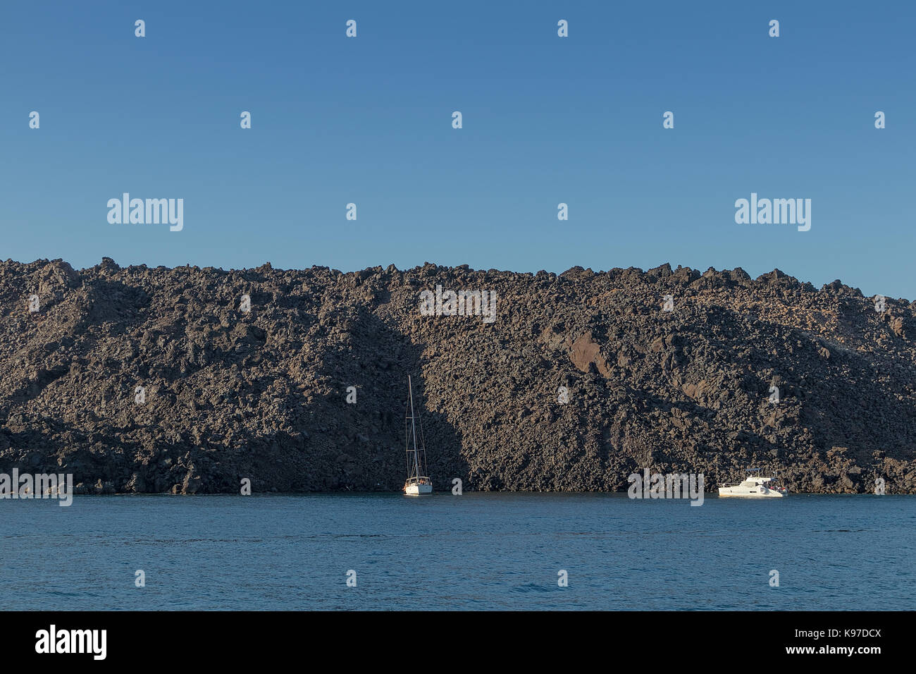 sailboat with cliff behind in the sea of santorini Stock Photo - Alamy