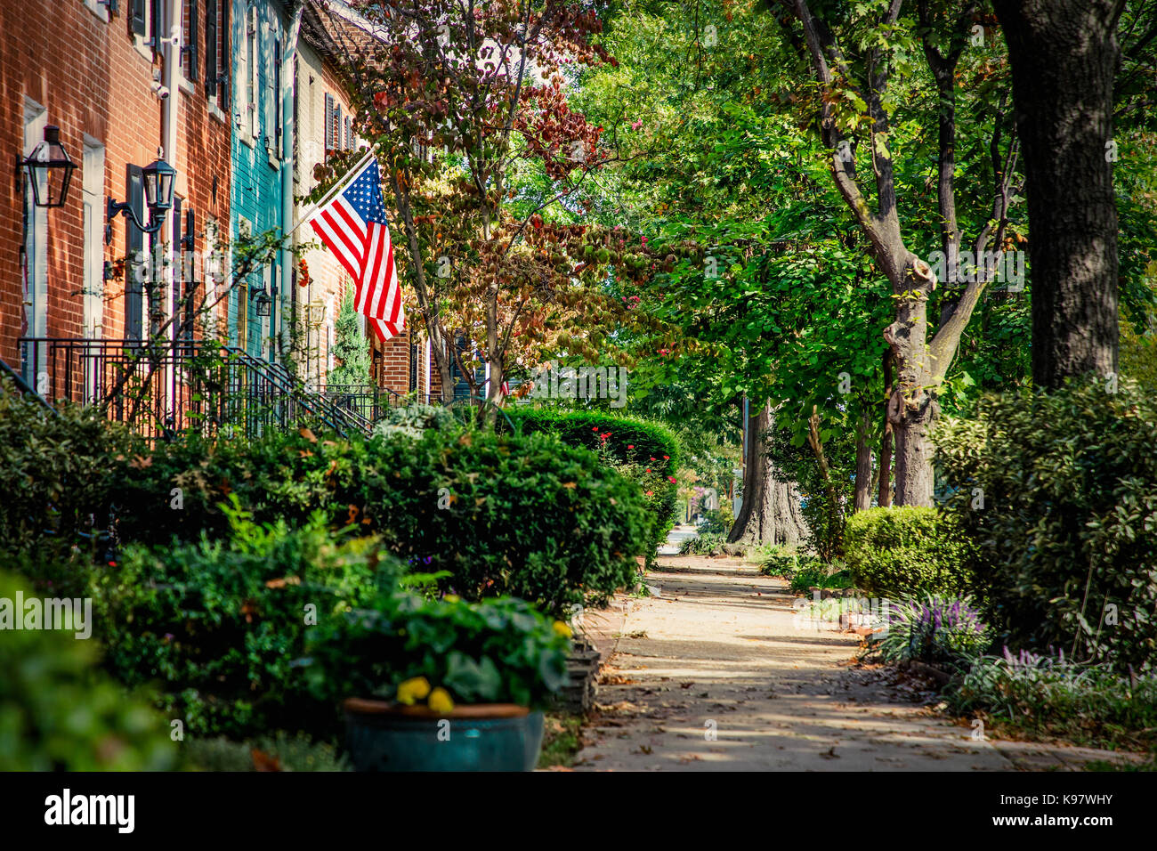 A flag flying over a Virginia street with cobblestone sidewalks and ...