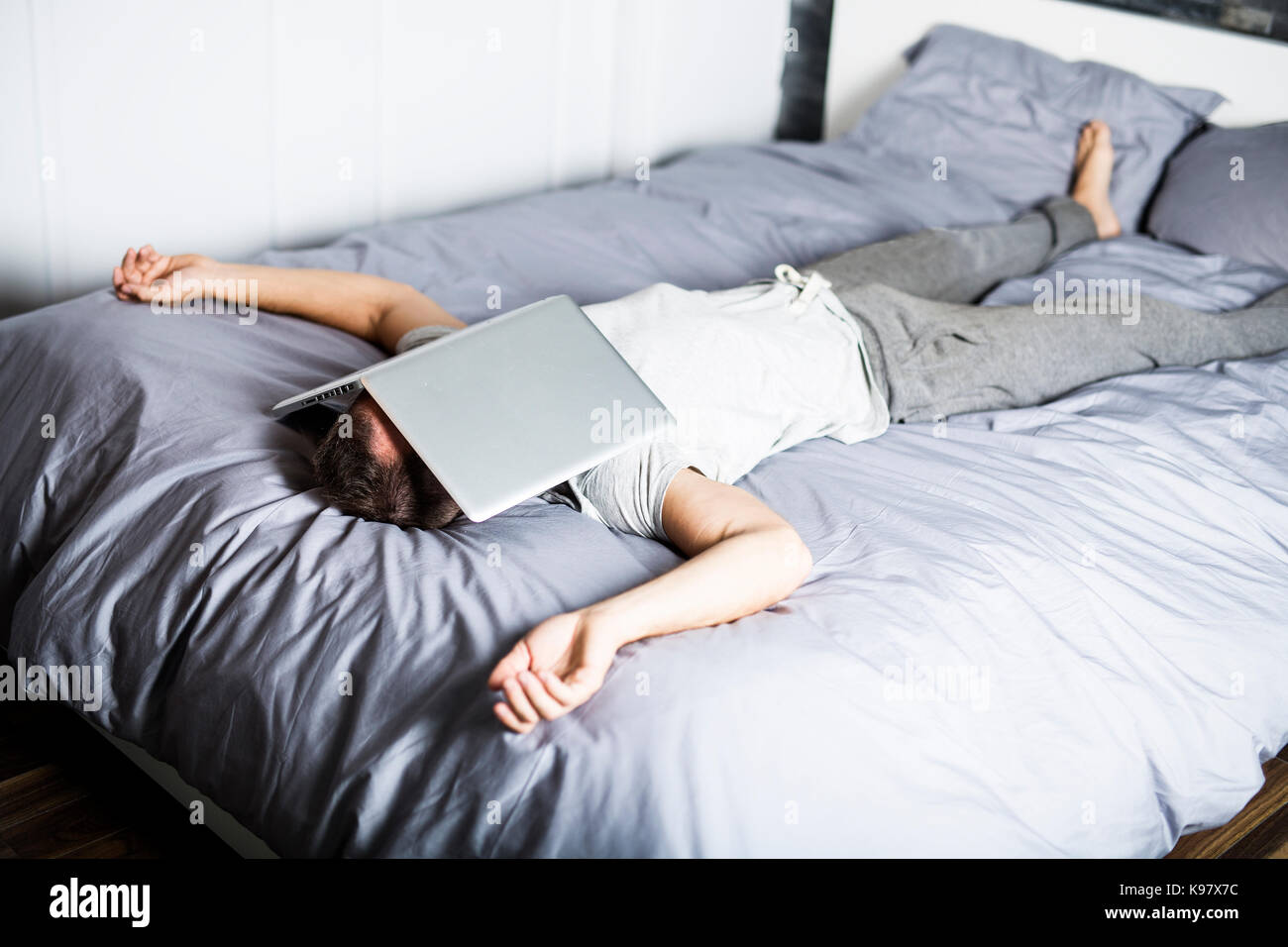 man sleeping over laptop computer in bed Stock Photo - Alamy