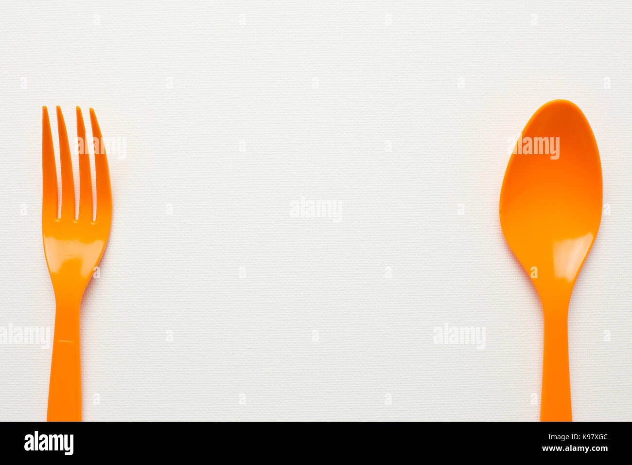 Close up of orange spoon and fork on white canvas background Stock ...