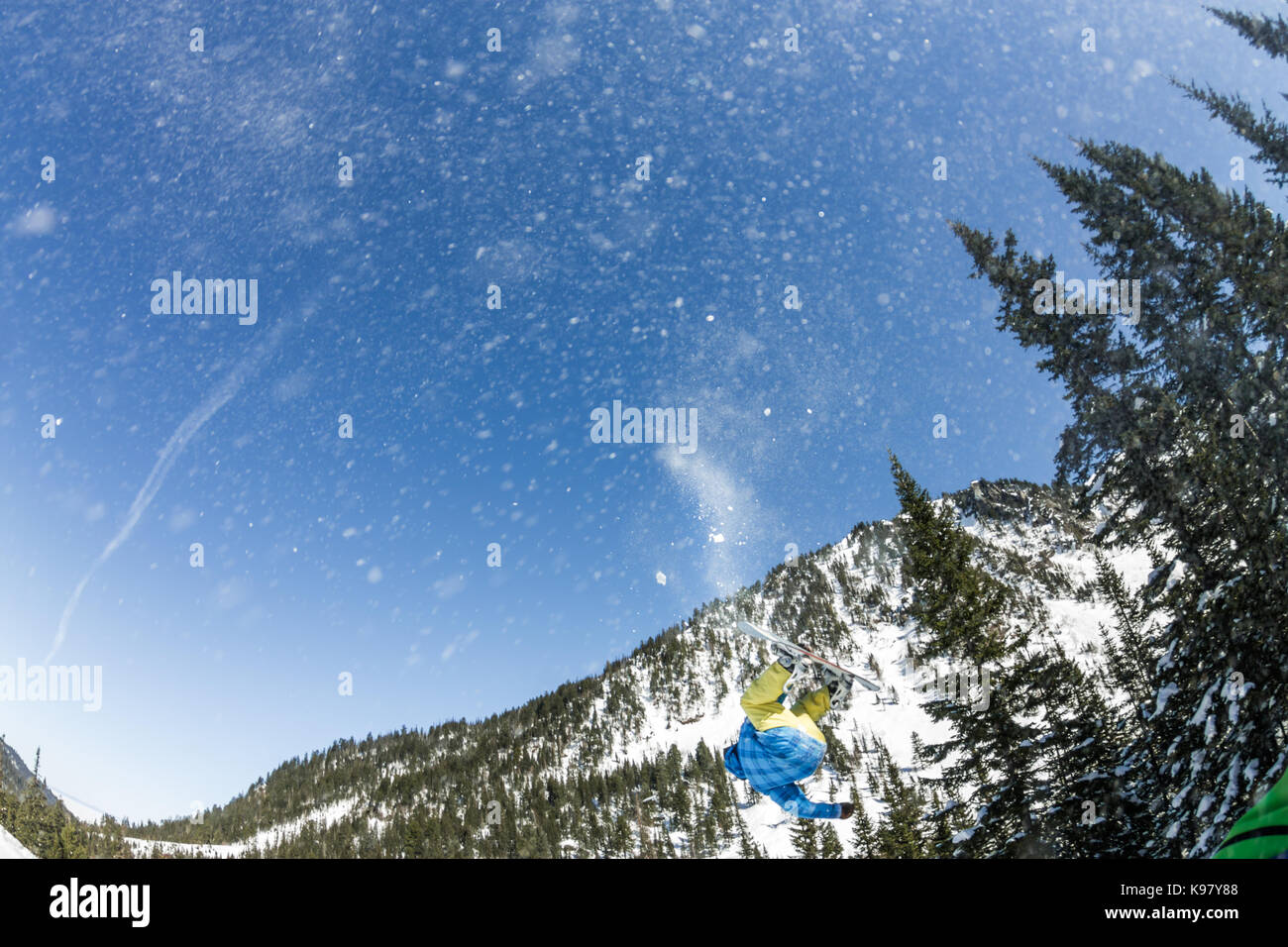 Snowboarder freerider jumping from a snow ramp in the sun on a ...