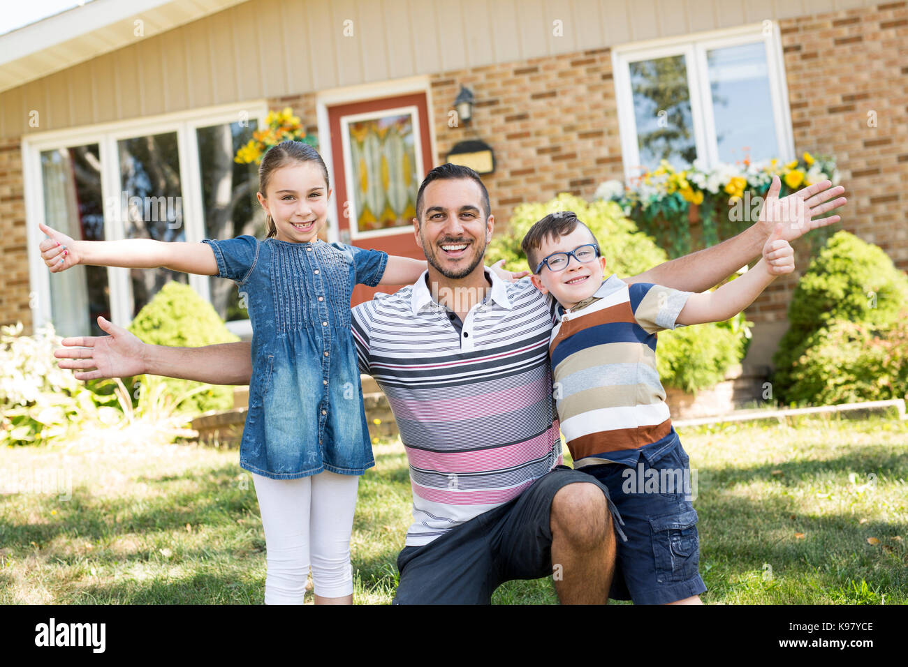 Portrait of happy family in front house Stock Photo - Alamy
