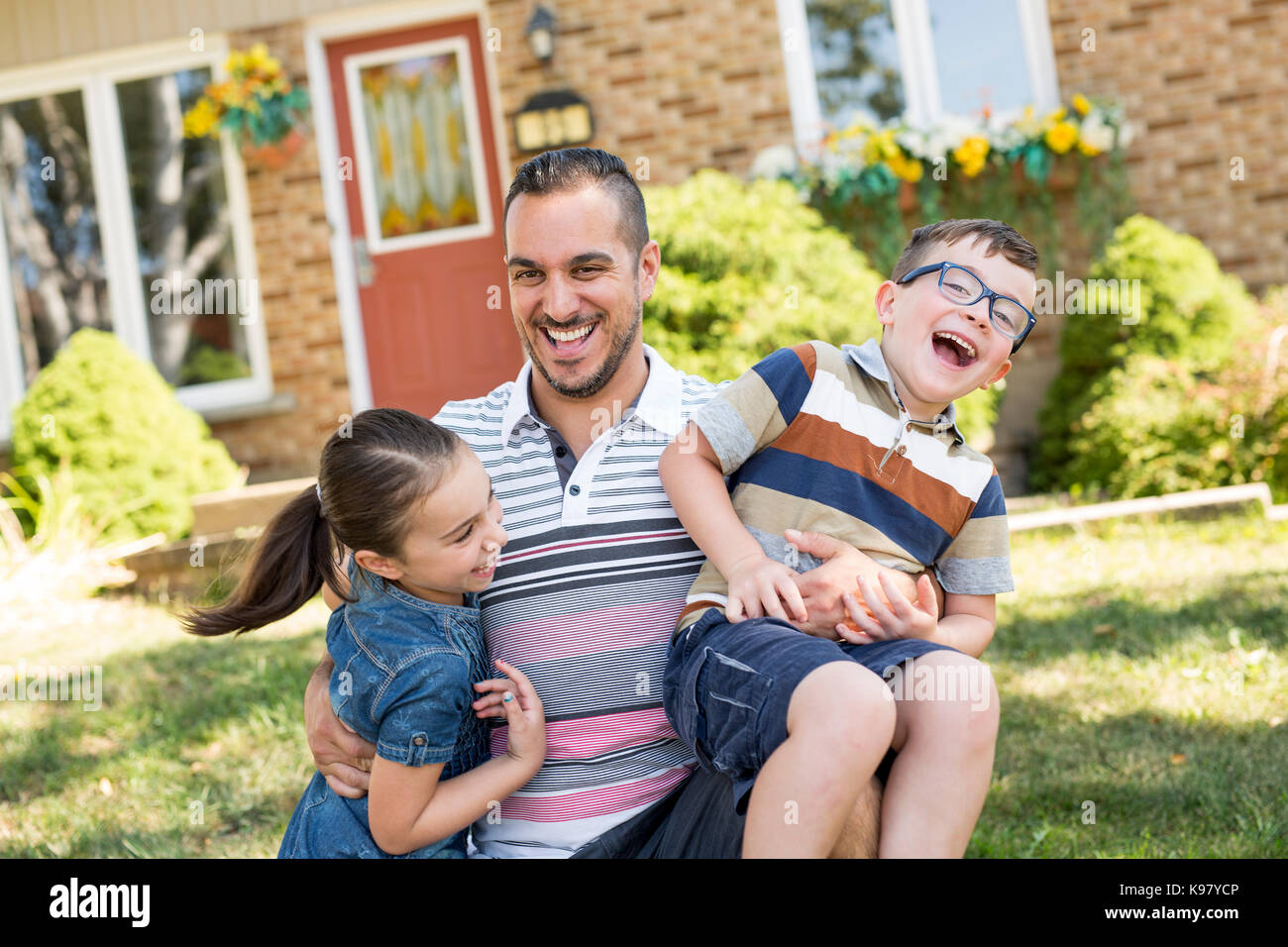 Portrait of happy family in front house Stock Photo - Alamy