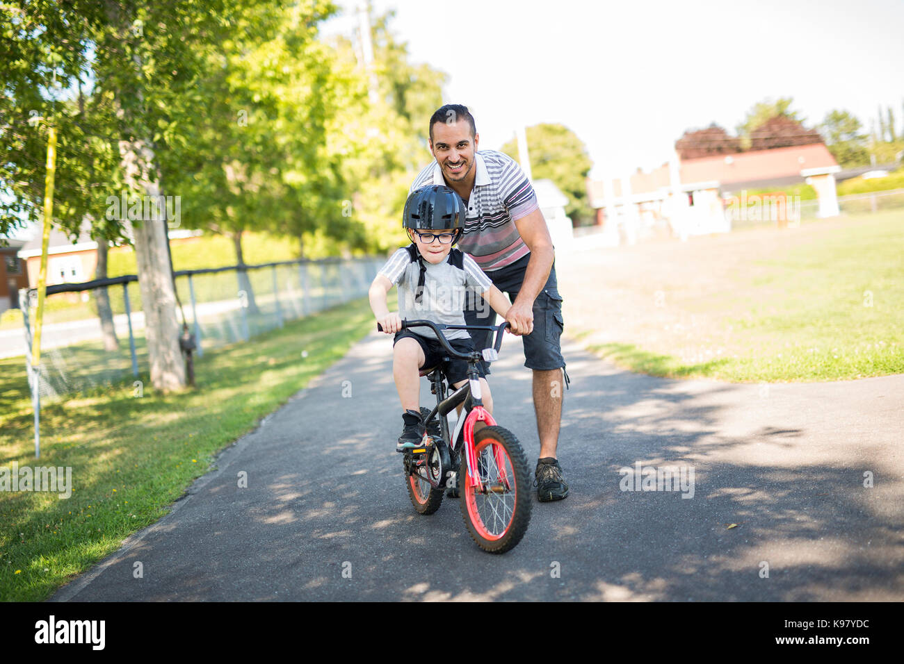 Father Teaching Son To Ride Bicycle Stock Photo - Alamy