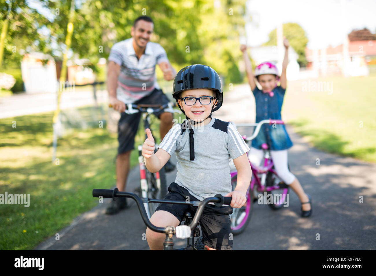 Family riding bikes park helmet hi-res stock photography and images - Alamy